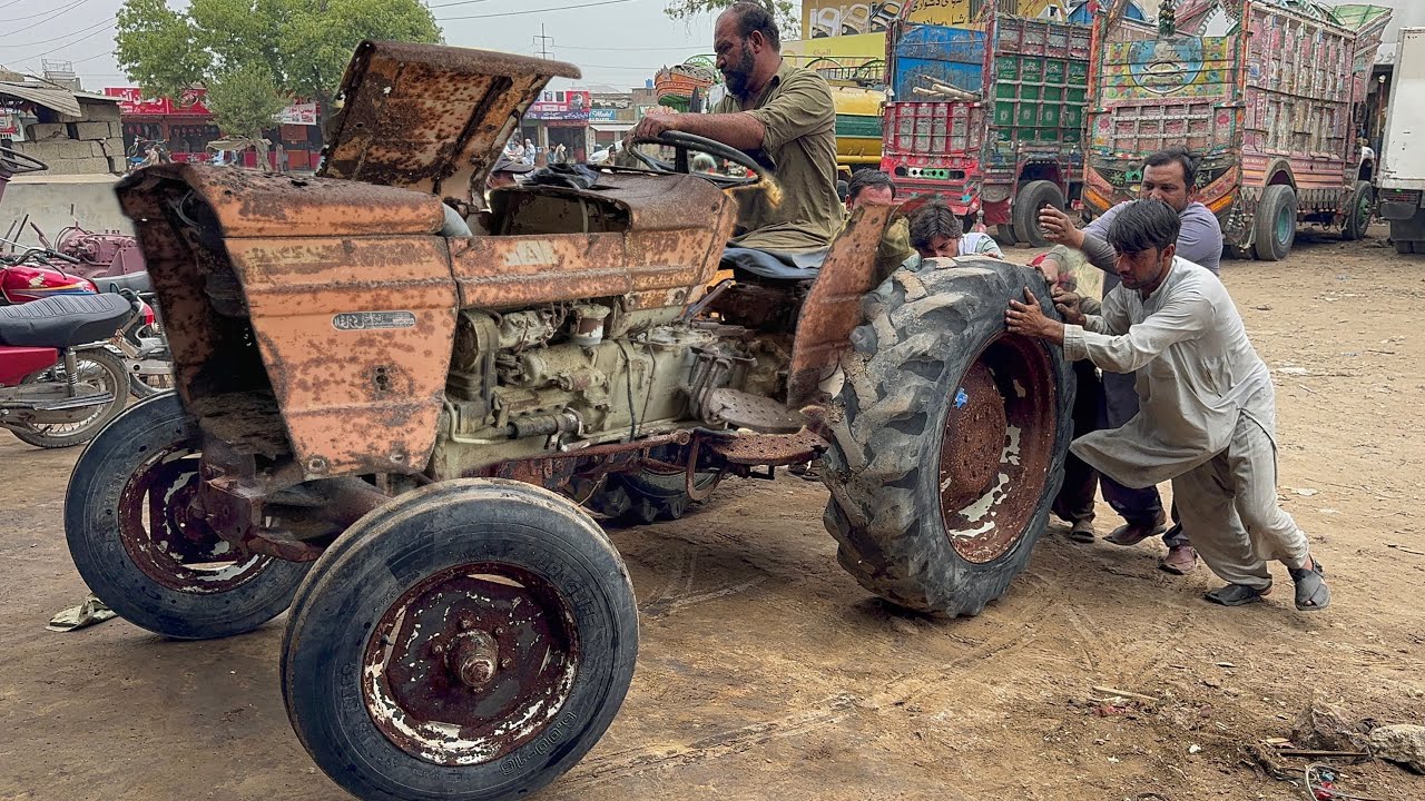 An Expert Mechanic Repairs A Rusty Tractor That Has Been Left In The